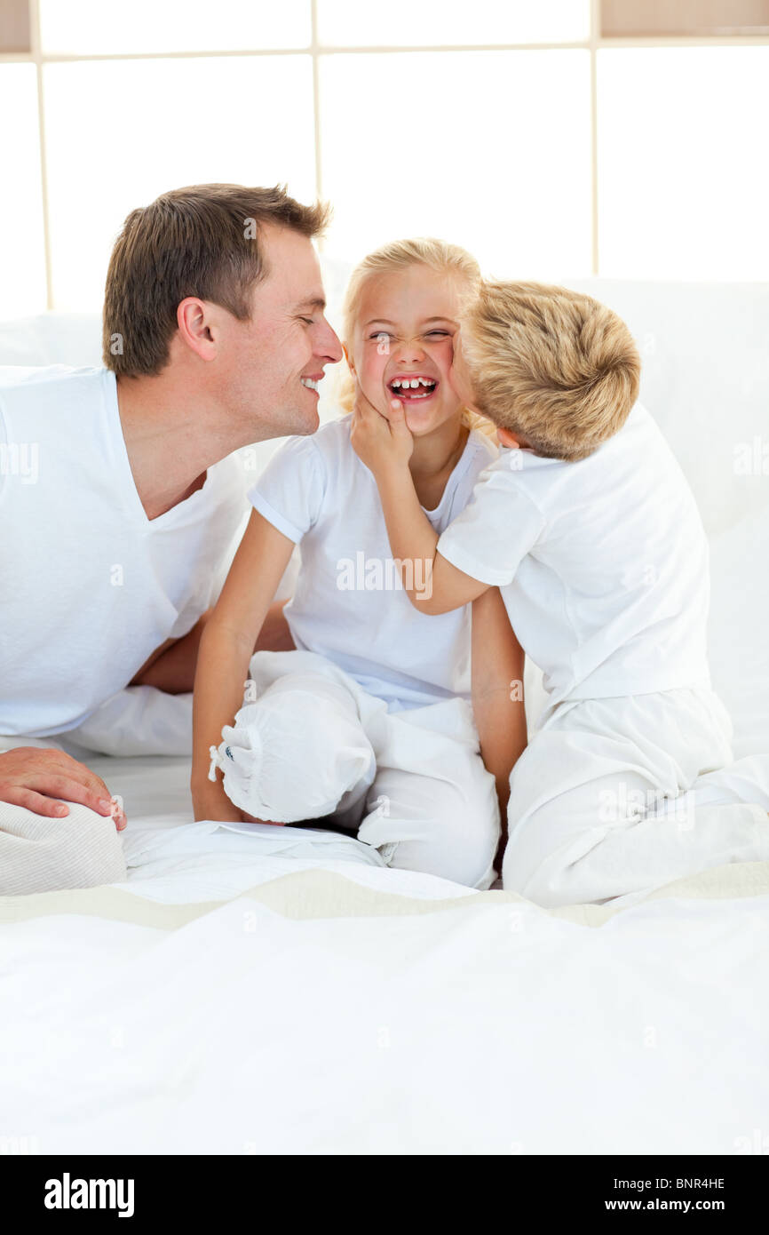 Cute siblings playing with their father Stock Photo - Alamy