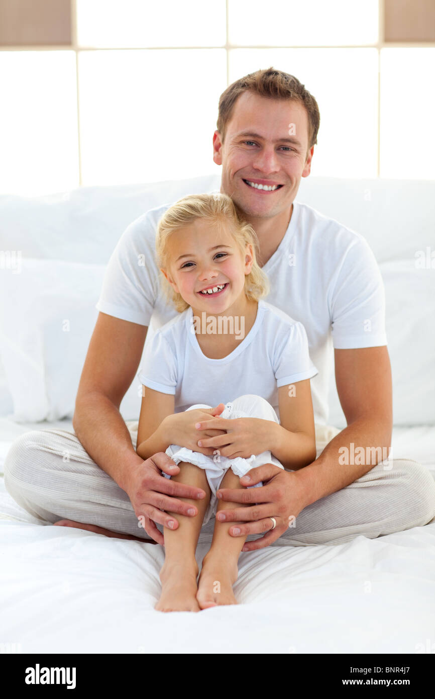 Caring father with his little girl sitting on bed Stock Photo - Alamy