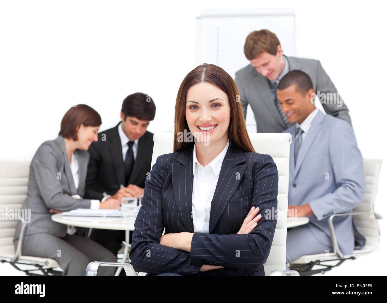Confident manager with folded arms in front on his team Stock Photo - Alamy