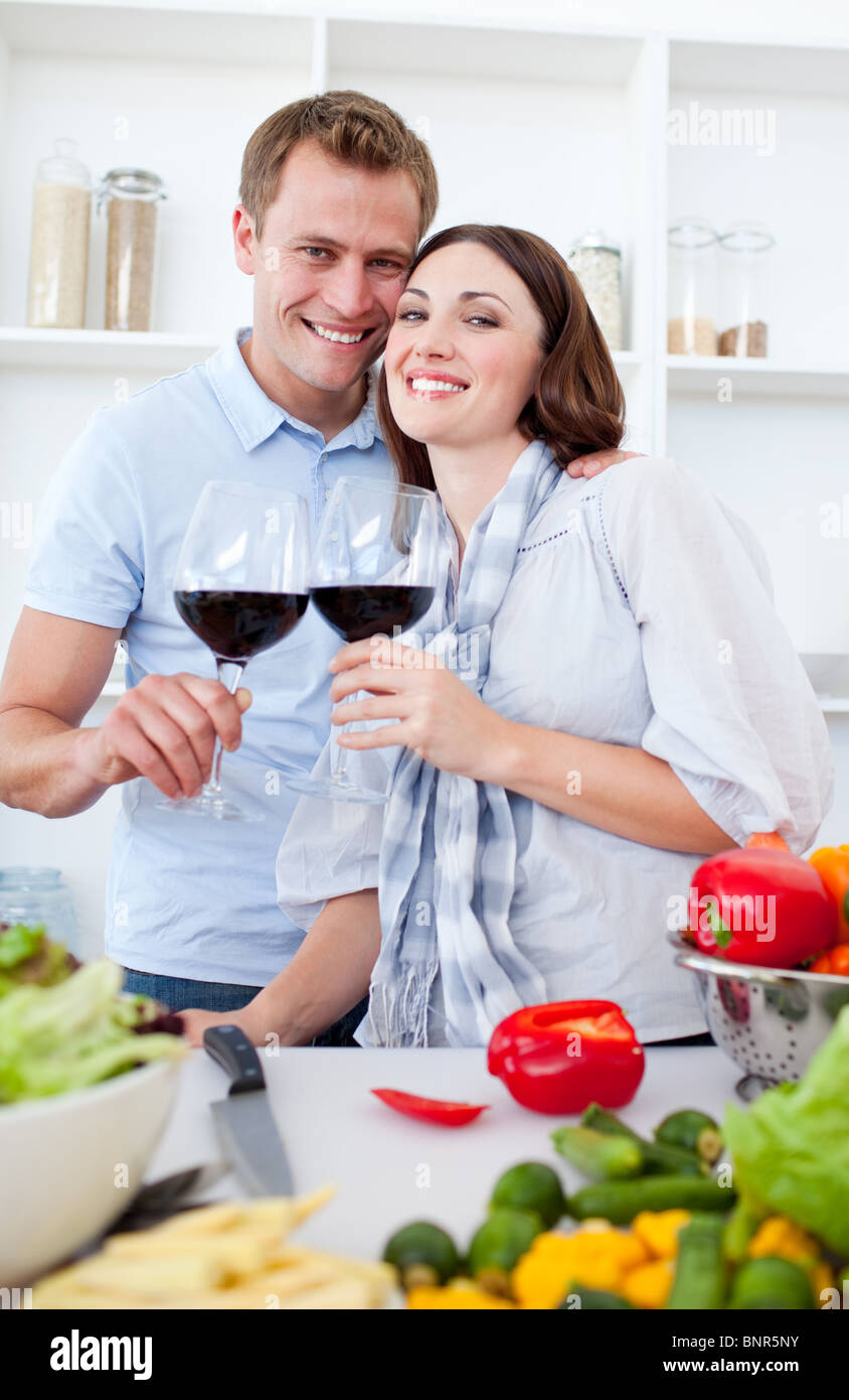 Smiling couple drinking wine while cooking Stock Photo - Alamy
