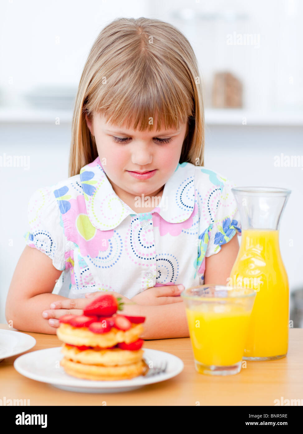 Cute little girl eating waffles with strawberries Stock Photo - Alamy
