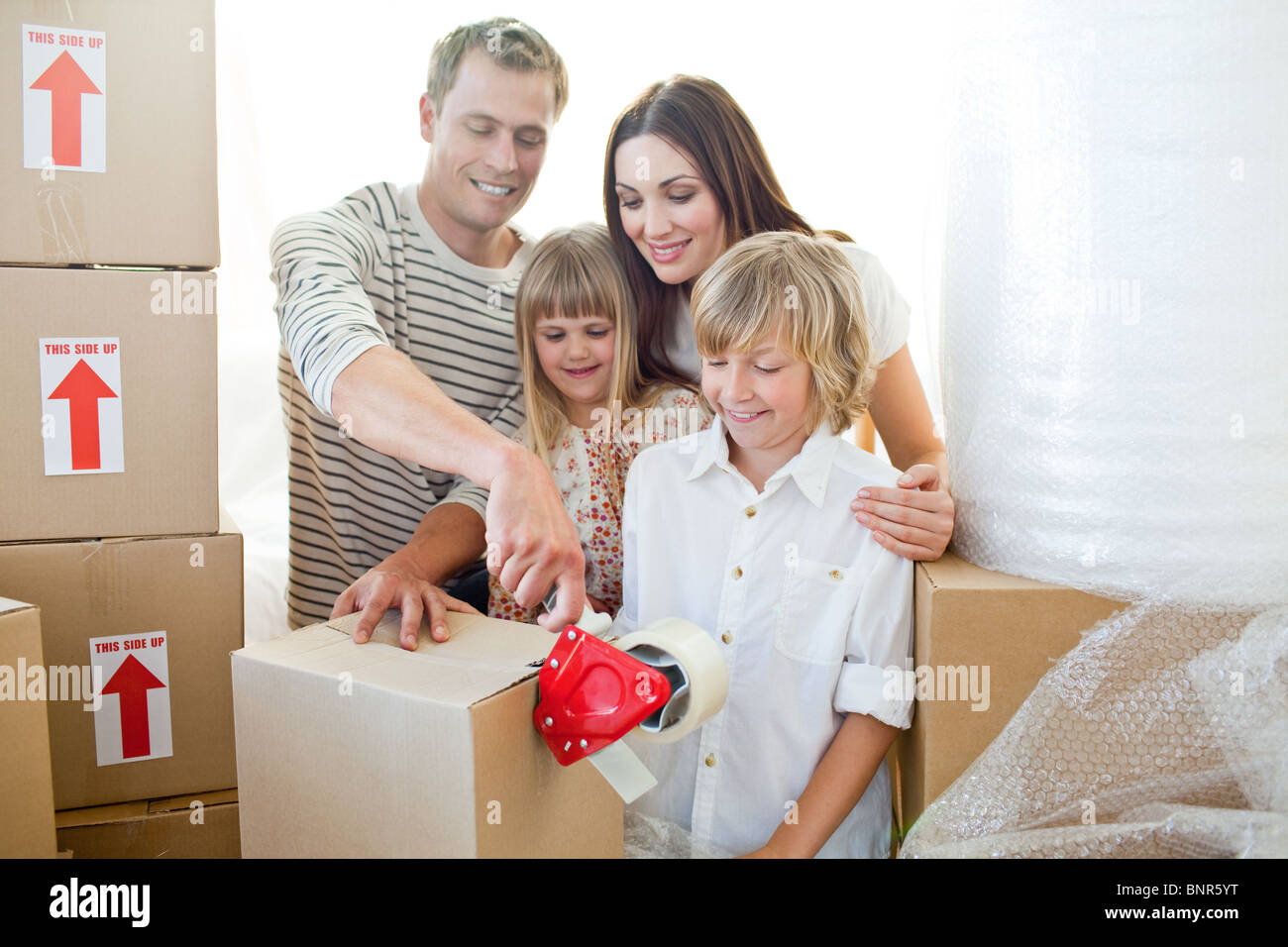 Merry family packing boxes Stock Photo - Alamy