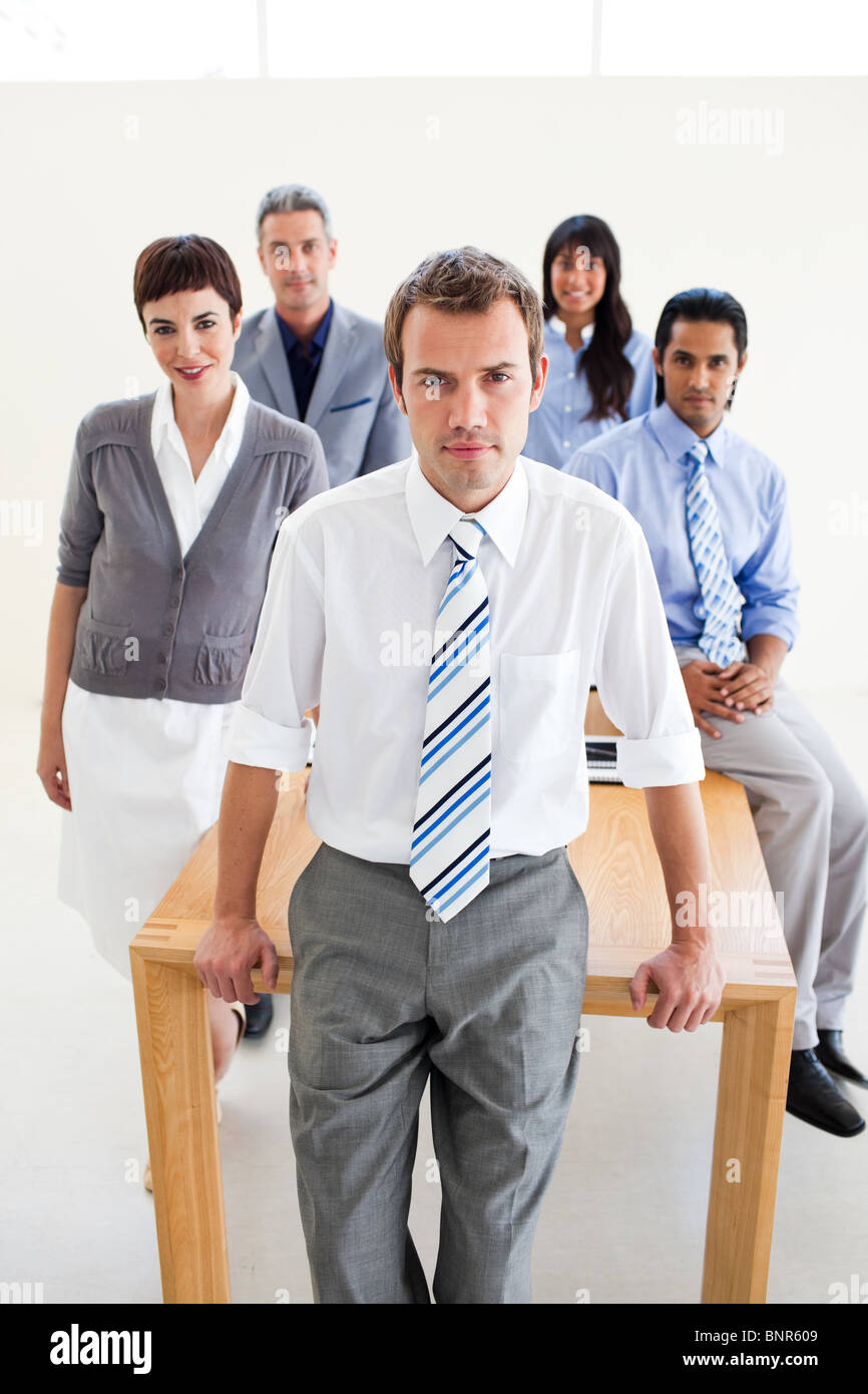Business team standing around a table Stock Photo - Alamy