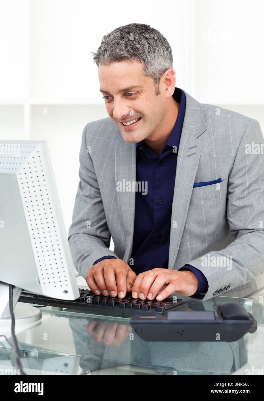 Positive businessman working at a computer Stock Photo - Alamy