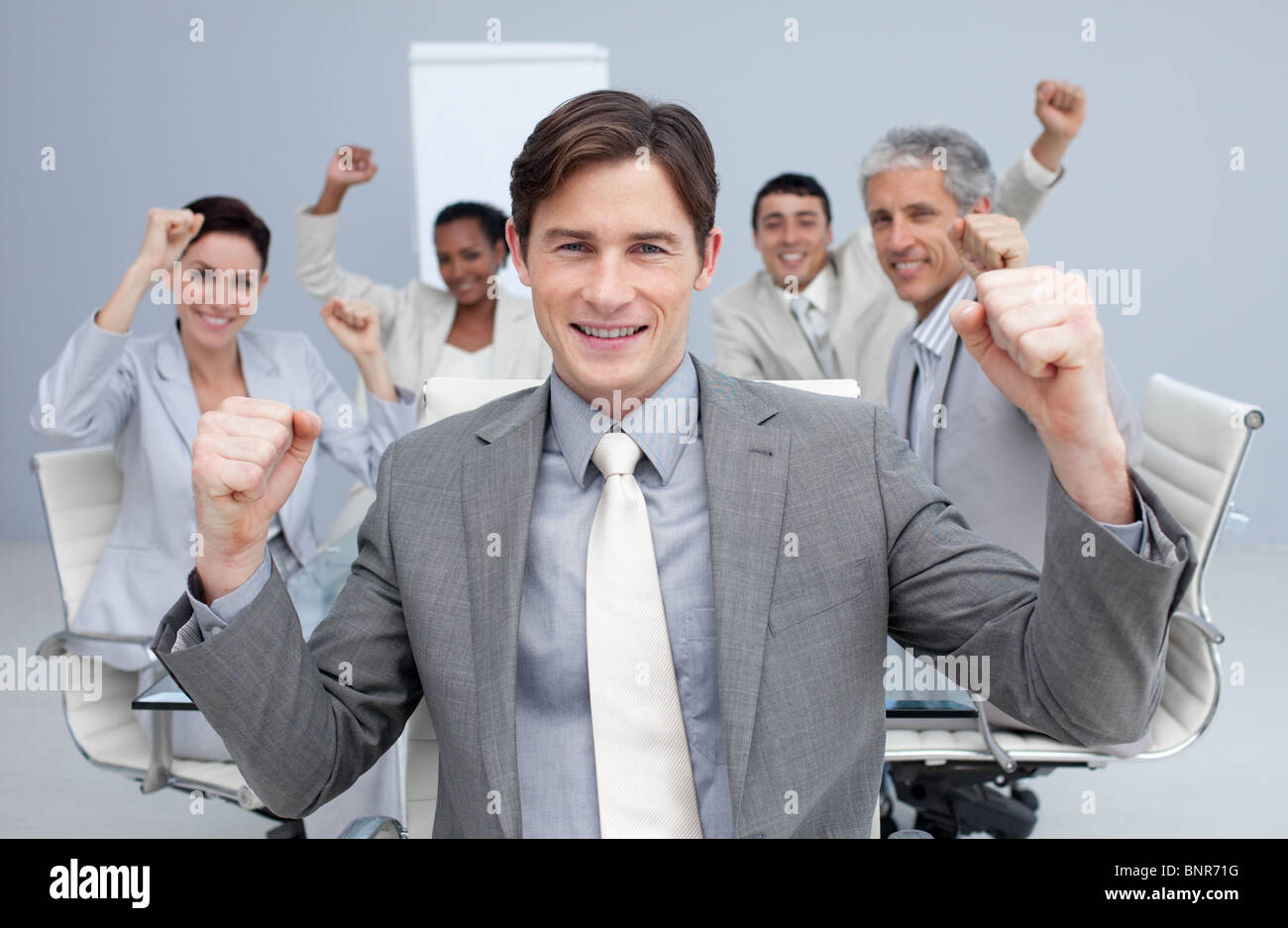 Happy business team celebrating a sucess with hands up Stock Photo - Alamy