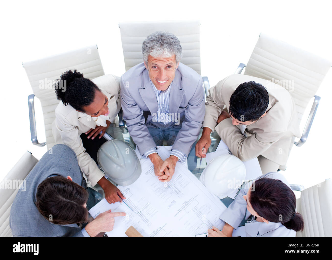 Positive multi-ethnic architects studying blueprints Stock Photo - Alamy
