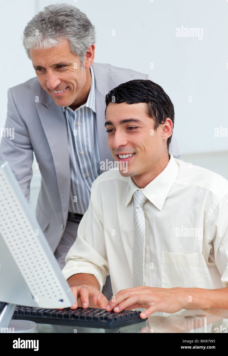 Mature businessman helping his colleague at a computer Stock Photo - Alamy