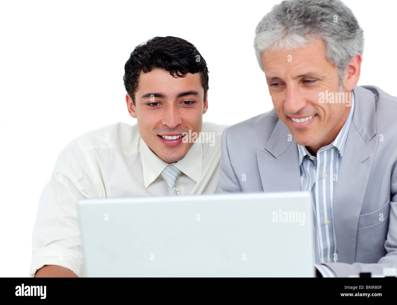 Assertive business co-workers using a laptop Stock Photo - Alamy