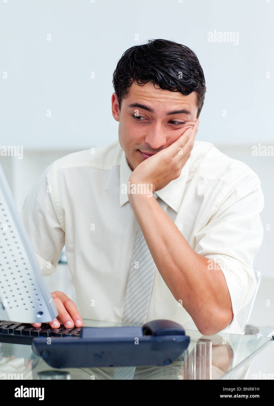 Bored young businessman at his desk Stock Photo - Alamy