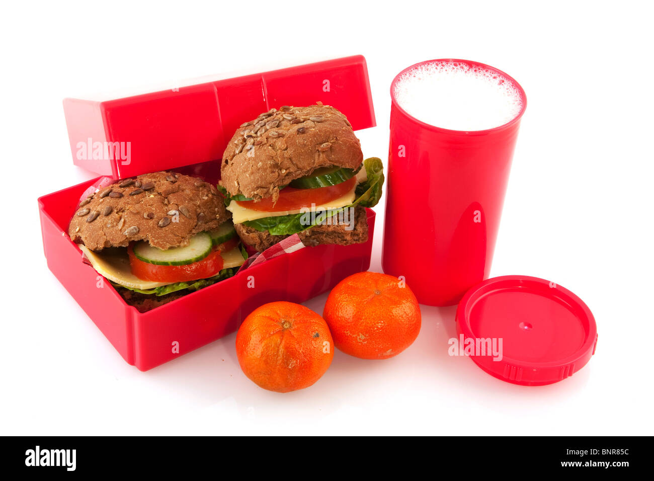 Healthy filled red lunchbox with brown bread rolls fruit and milk Stock ...
