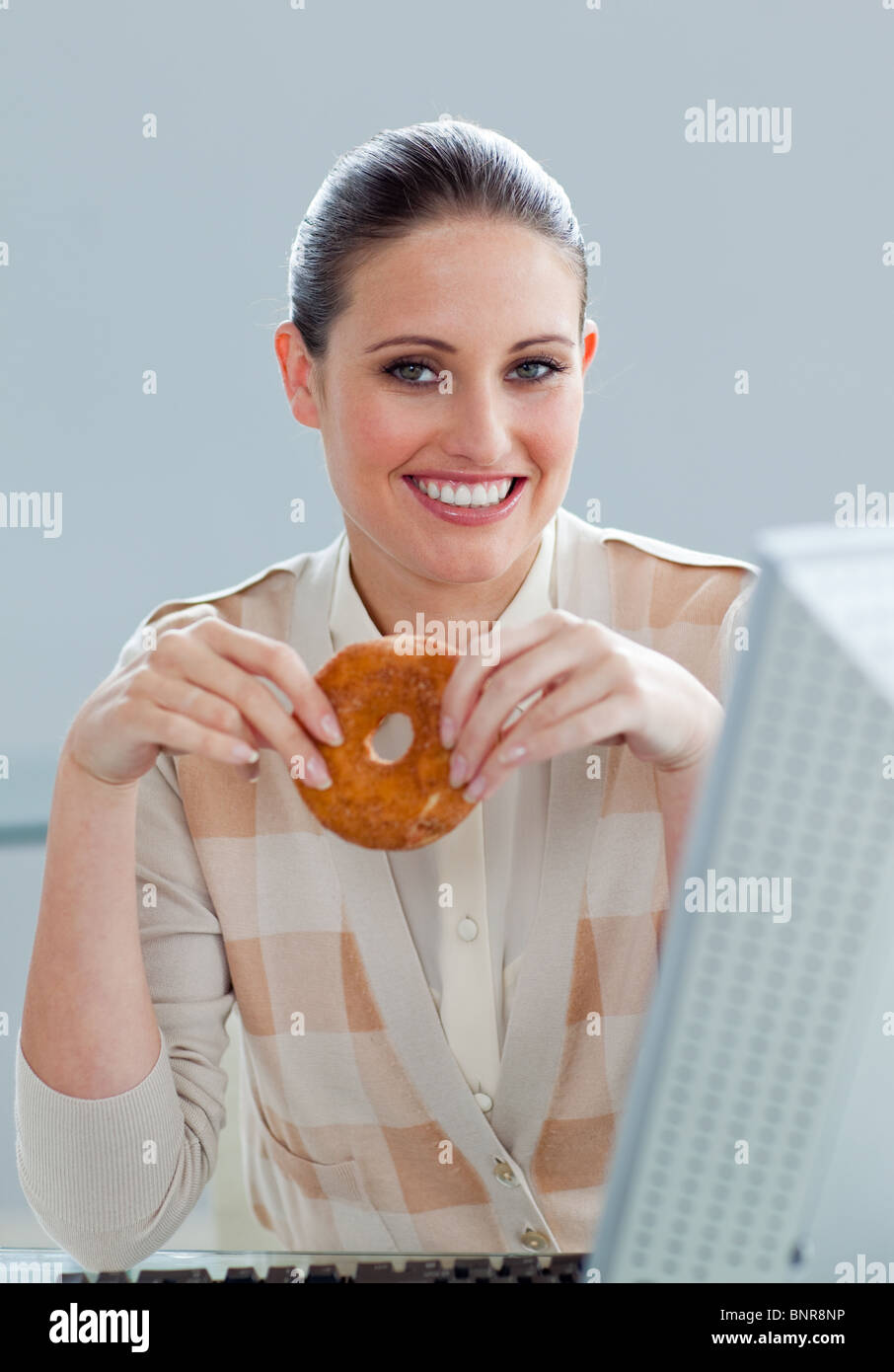 Young businesswoman eating a donut Stock Photo - Alamy