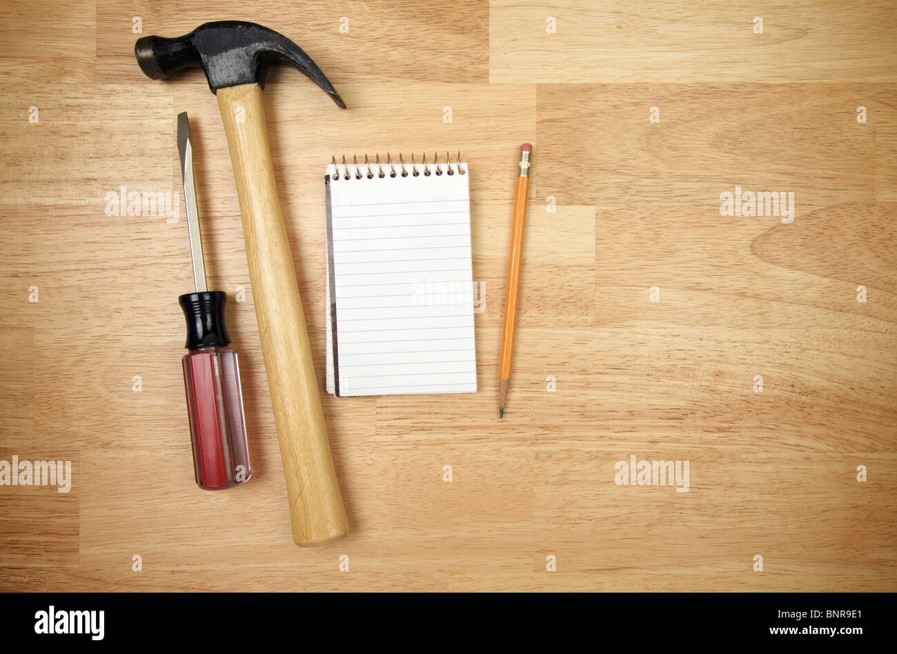 Pad of Paper, Pencil, Hammer and Screwdriver on a Wood Background Stock ...