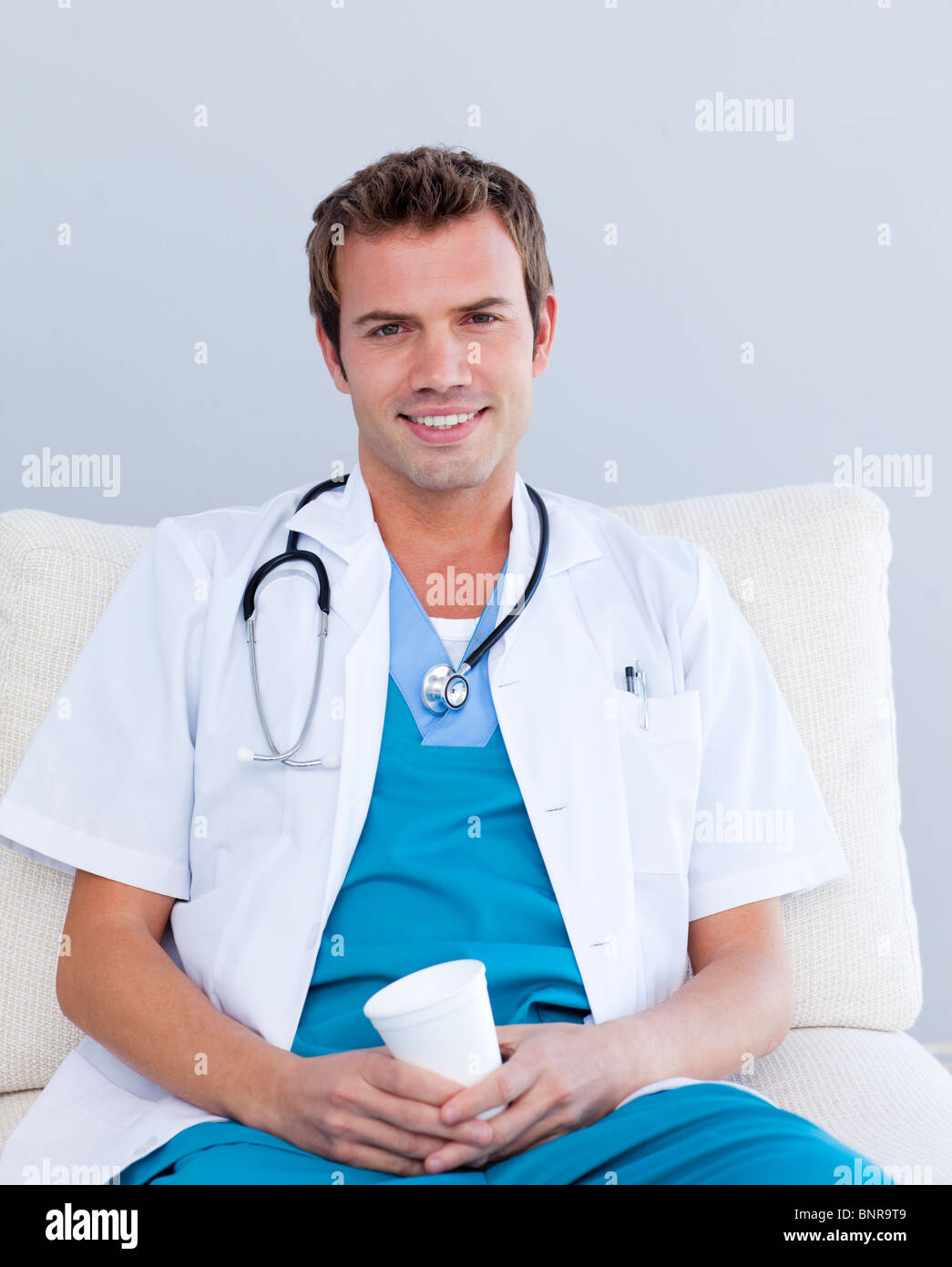Smiling male doctor drinking coffee Stock Photo - Alamy