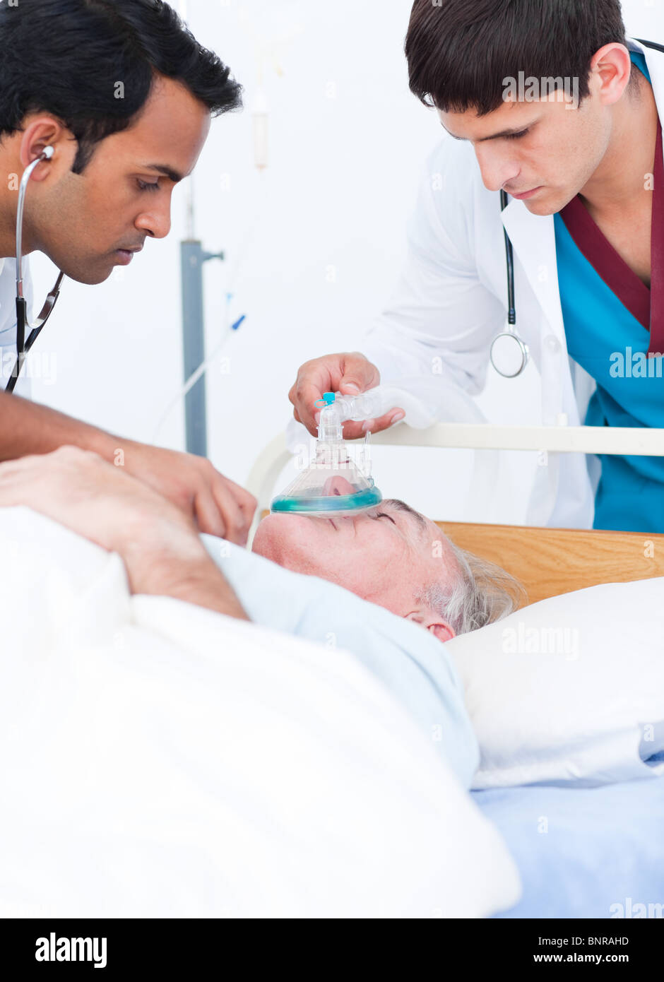Male doctor putting an oxygen mask to a patient hi-res stock ...