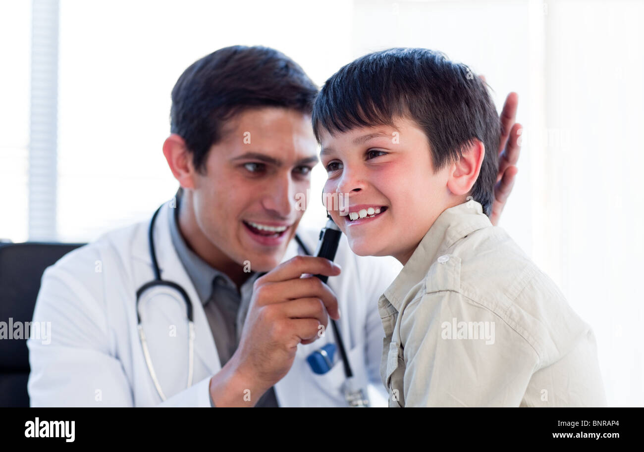 Smiling doctor examining little boy's ears Stock Photo - Alamy