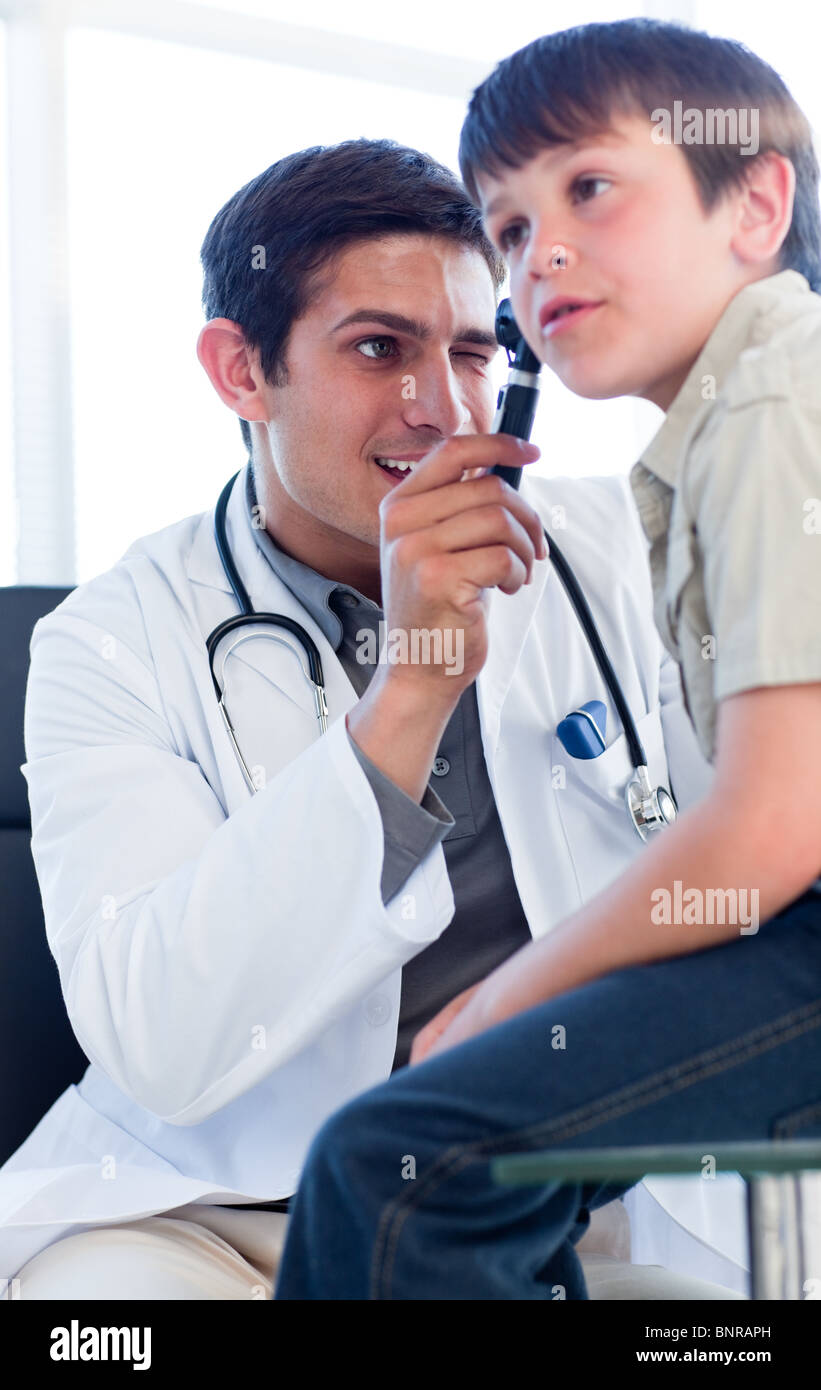 Charismatic doctor examining little boy's ears Stock Photo - Alamy