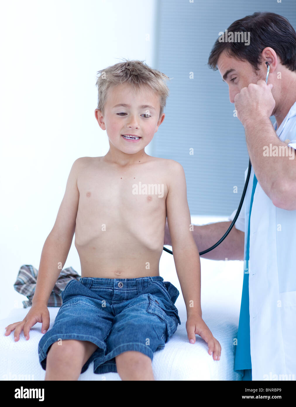 Doctor examinating a little boy with stethoscope Stock Photo - Alamy