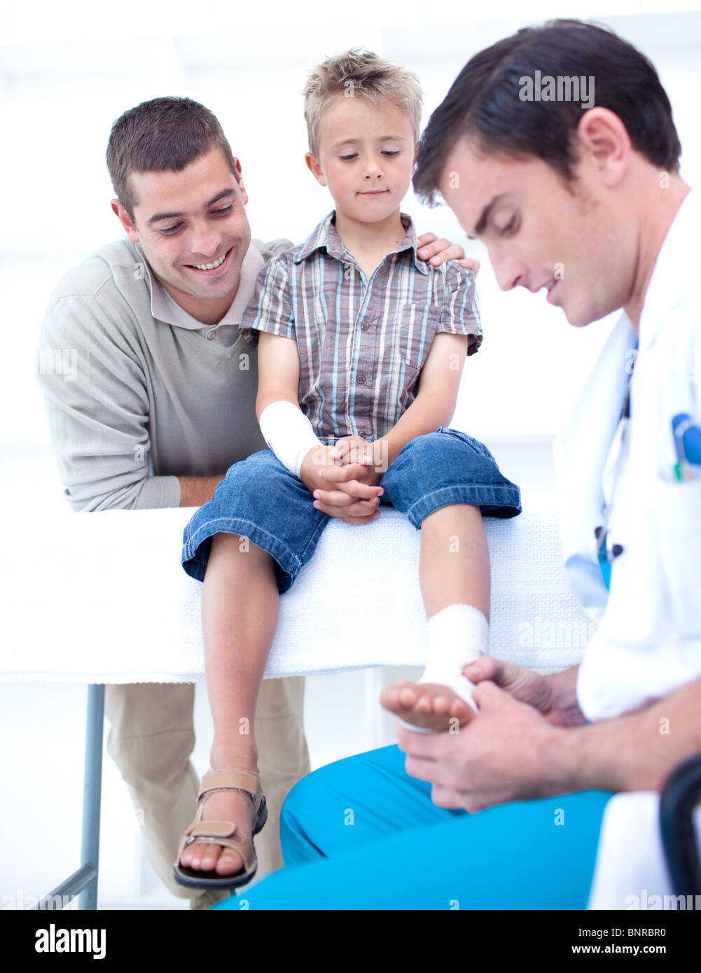 Doctor bandaging a child's foot Stock Photo - Alamy