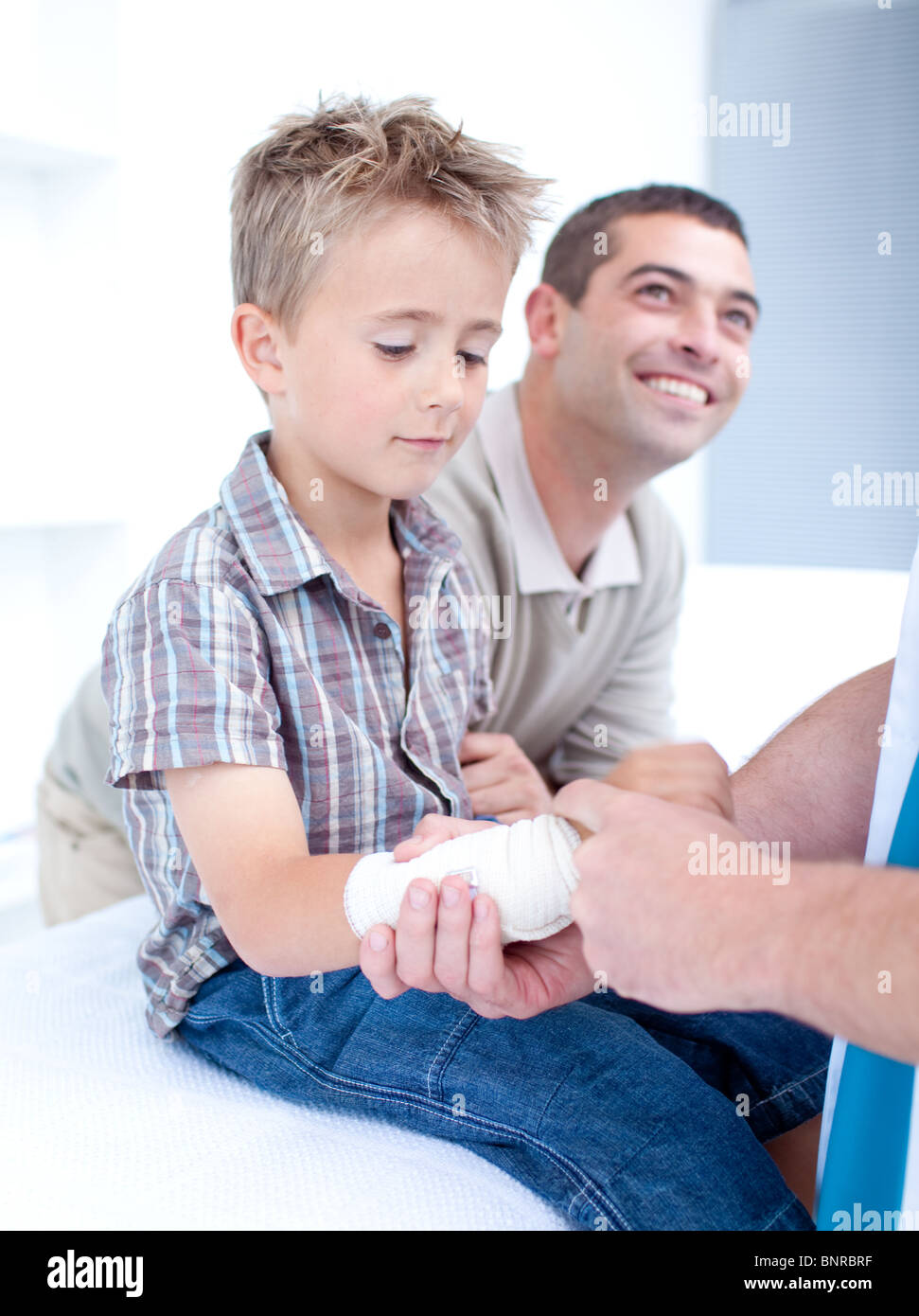 Bandaging an arm injury on a child Stock Photo - Alamy