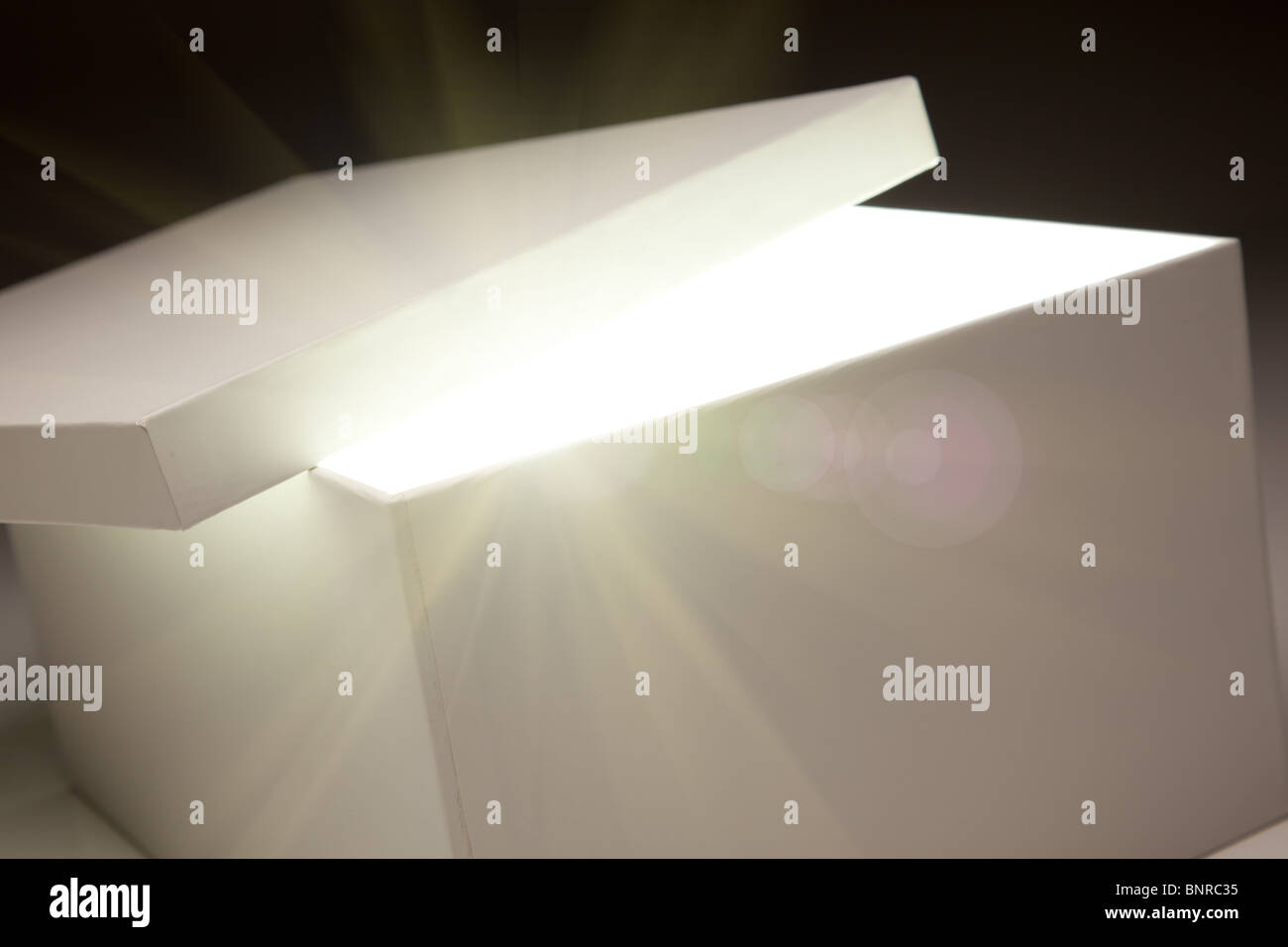 White Box with Lid Revealing Something Very Bright on a Grey Background ...