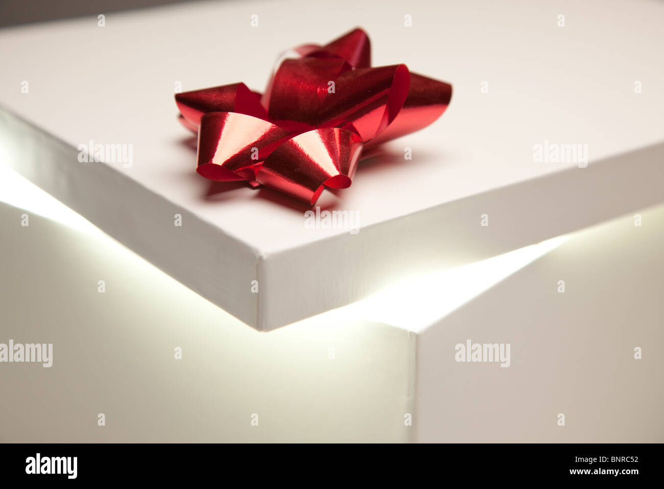 Gift Box with Red Bow Lid Revealing Very Bright Contents on a Gradated ...