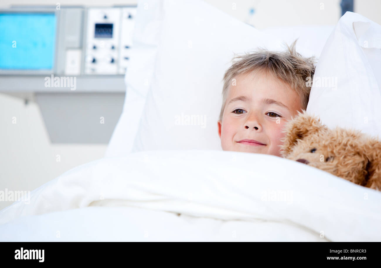 Sick cute little boy lying in a hospital bed Stock Photo - Alamy