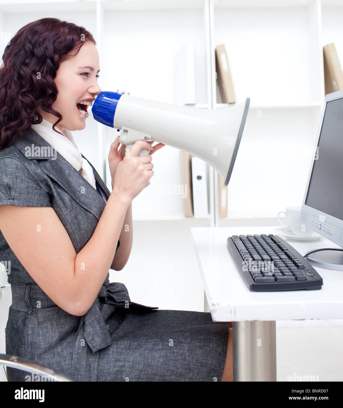 Businesswoman yelling through a megaphone Stock Photo - Alamy