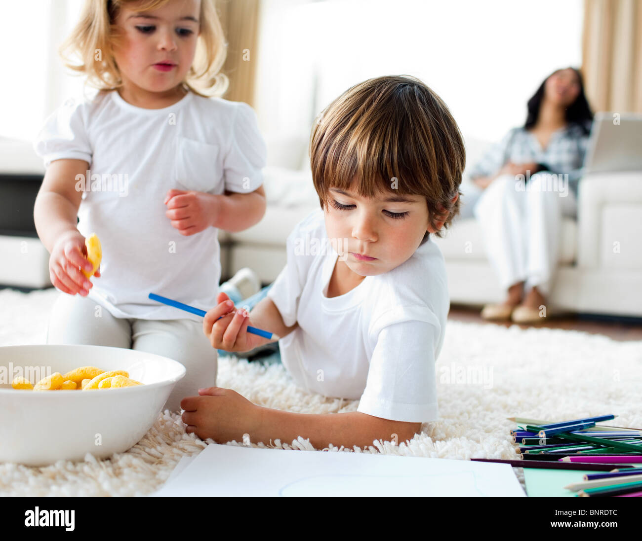 Adorable children eating chips and drawing Stock Photo - Alamy