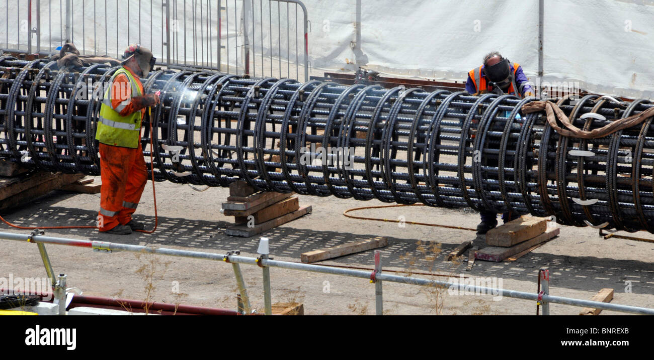 Men welding steel reinforcing rods prior to being lowered into ...