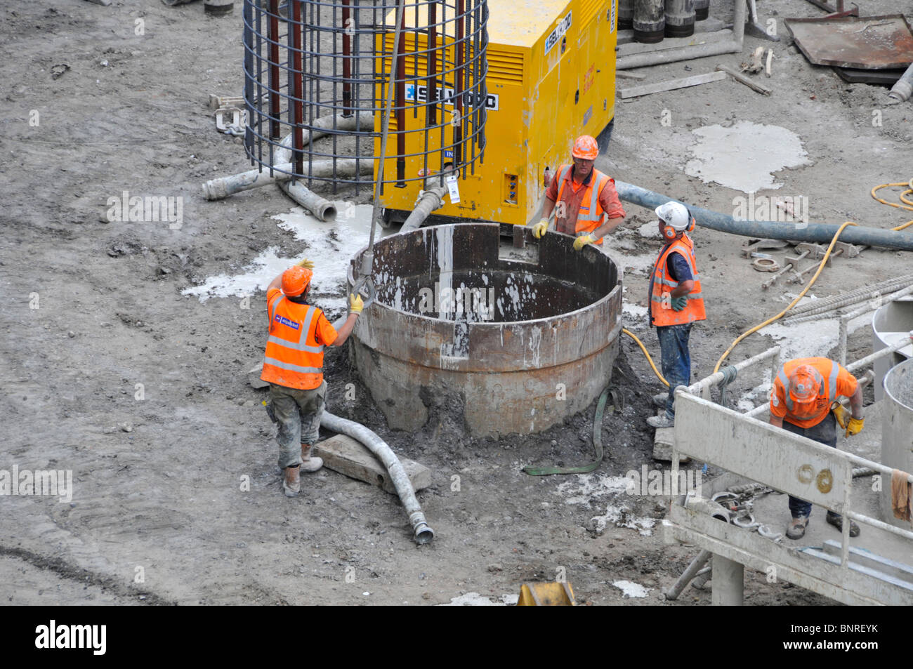 Steel reinforcing cage being lowered by crane into pile casing for ...