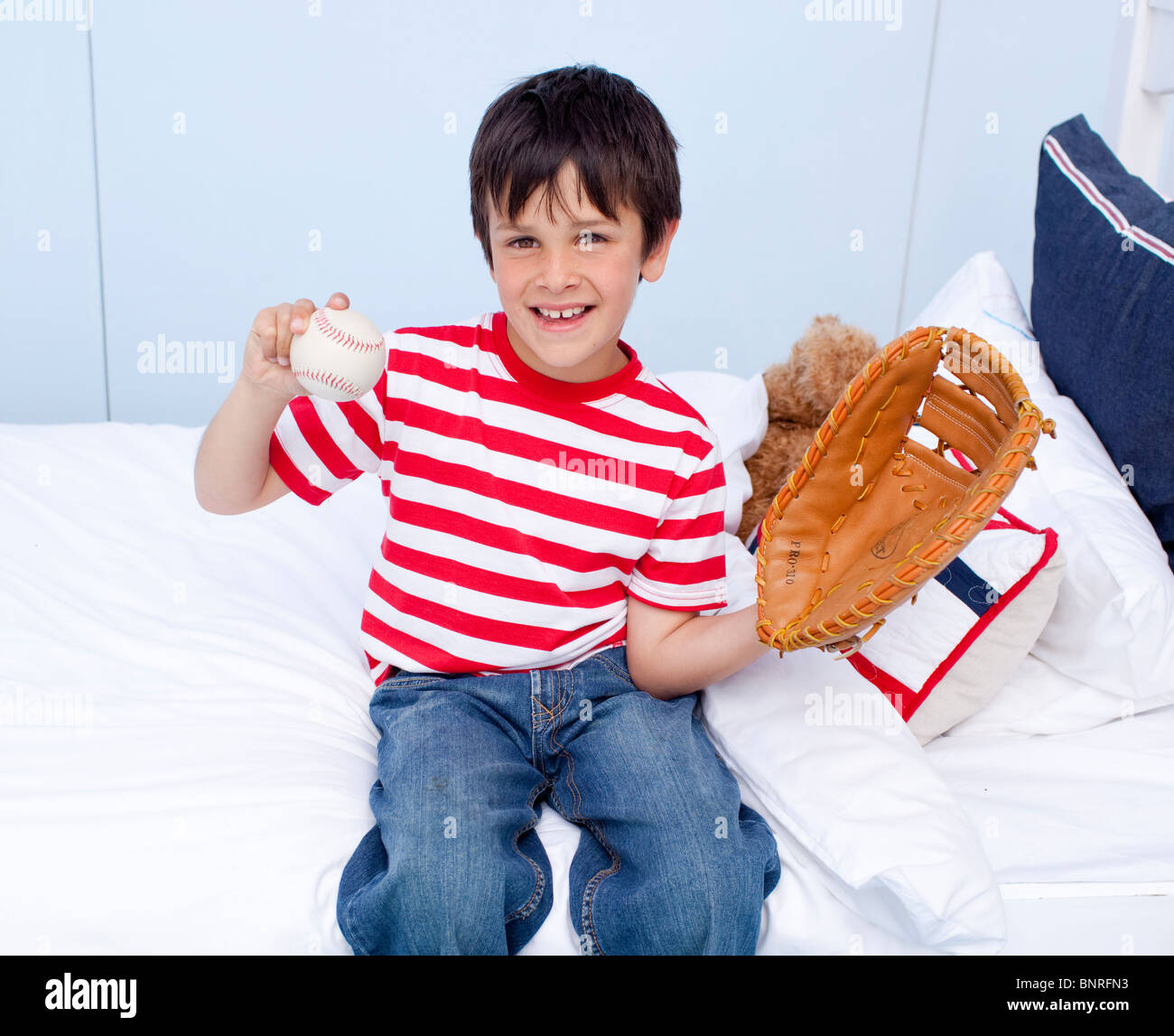 Happy little boy playing baseball in bed Stock Photo - Alamy
