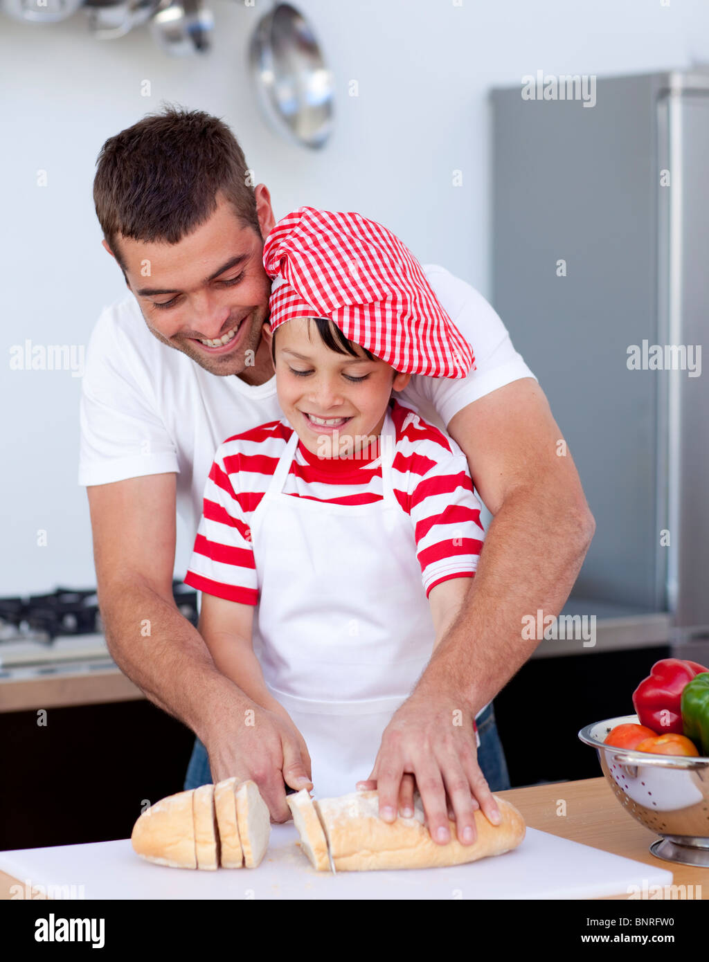 Man and little boy cutting bread Stock Photo - Alamy