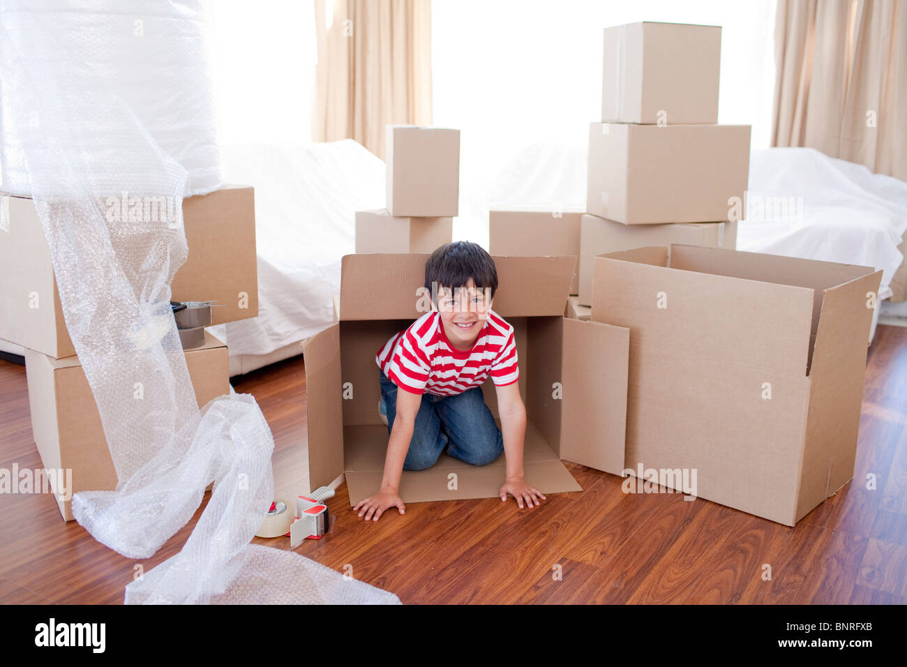 Kid playing with boxes in new house Stock Photo - Alamy