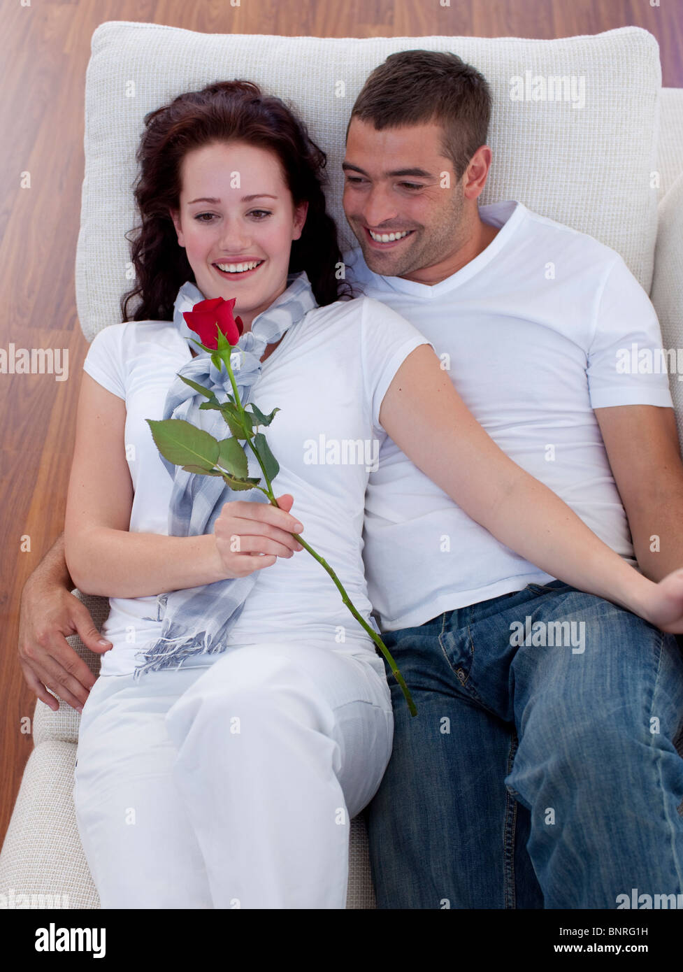 Lovers on sofa with a rose Stock Photo - Alamy