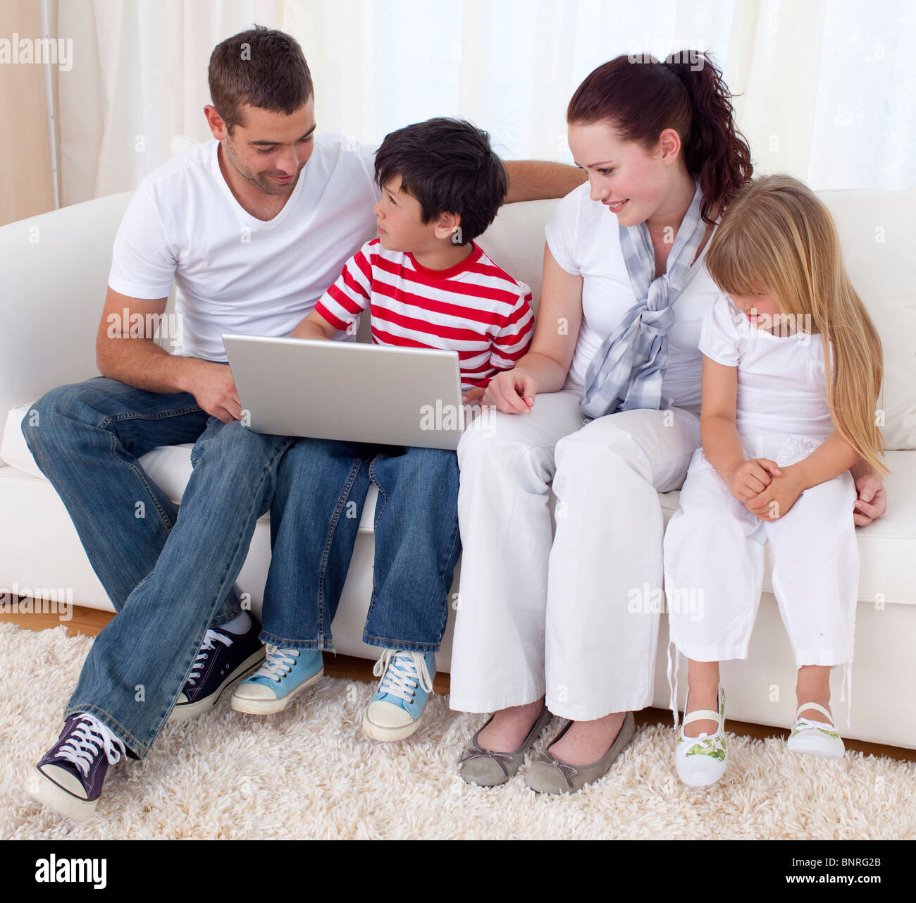 Family at home using a laptop Stock Photo - Alamy