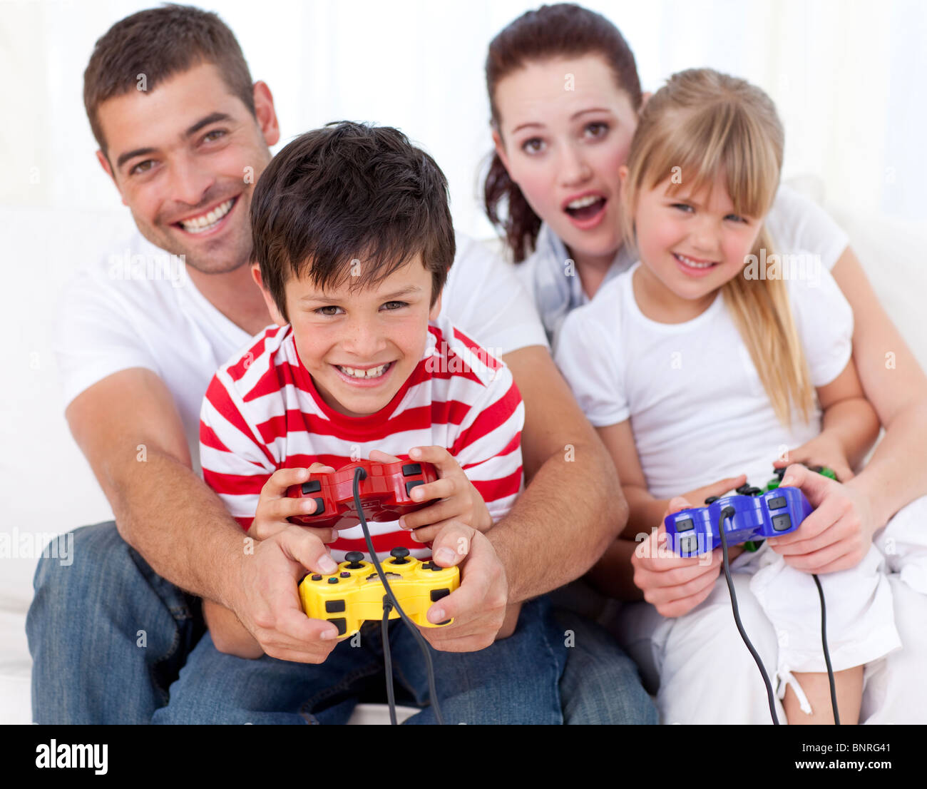 Family playing video games at home Stock Photo - Alamy