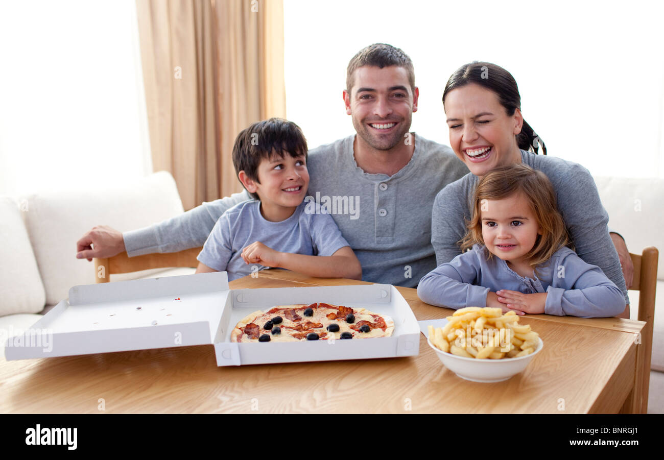 Family eating pizza and fries on a sofa Stock Photo - Alamy