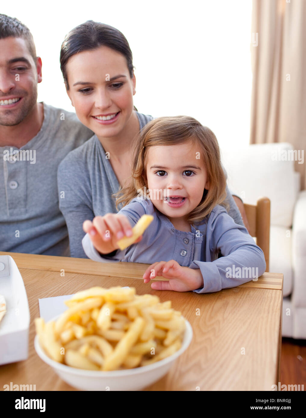 Little girl eating fries at home Stock Photo - Alamy