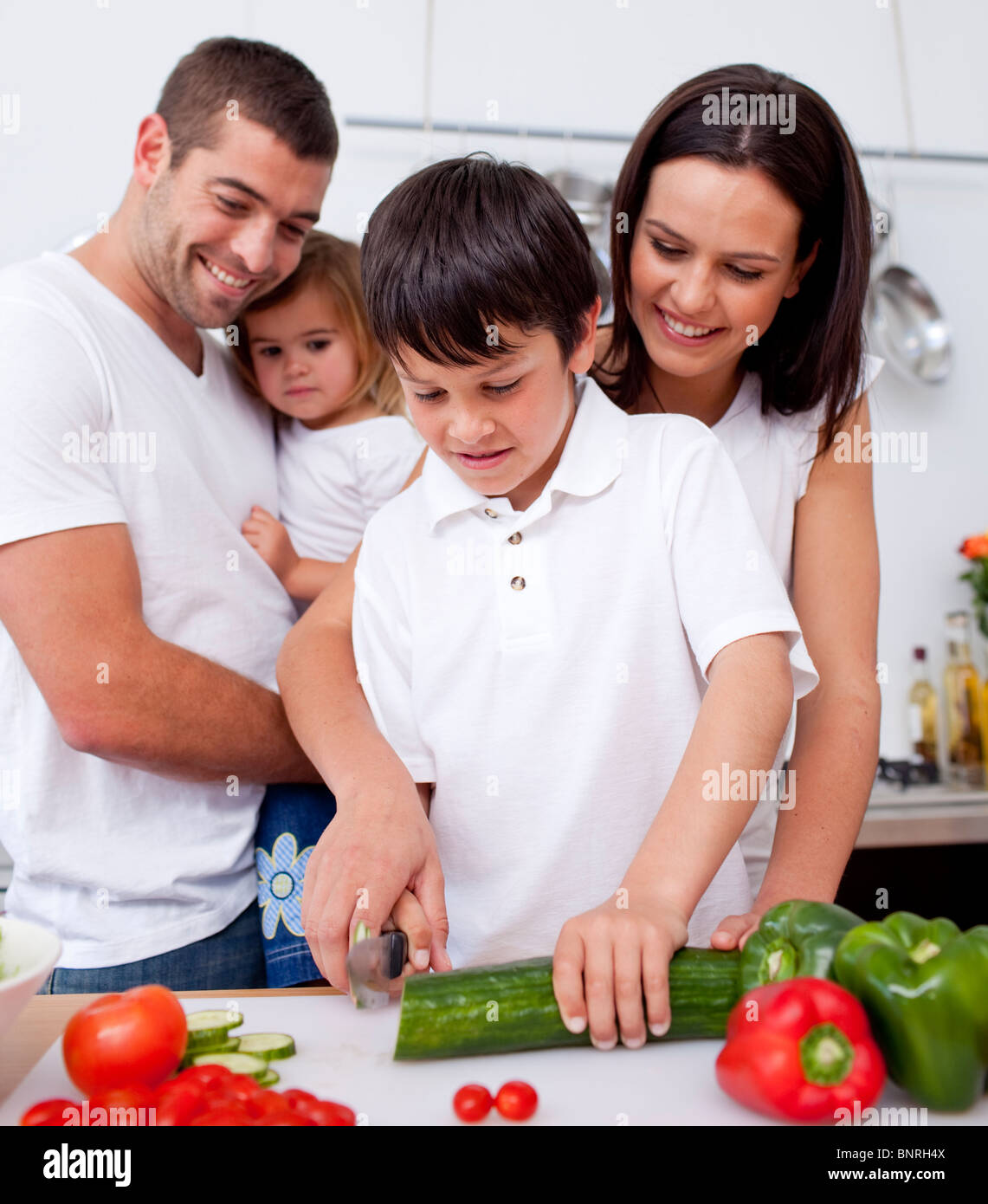 Little boy preparing food with his family Stock Photo - Alamy