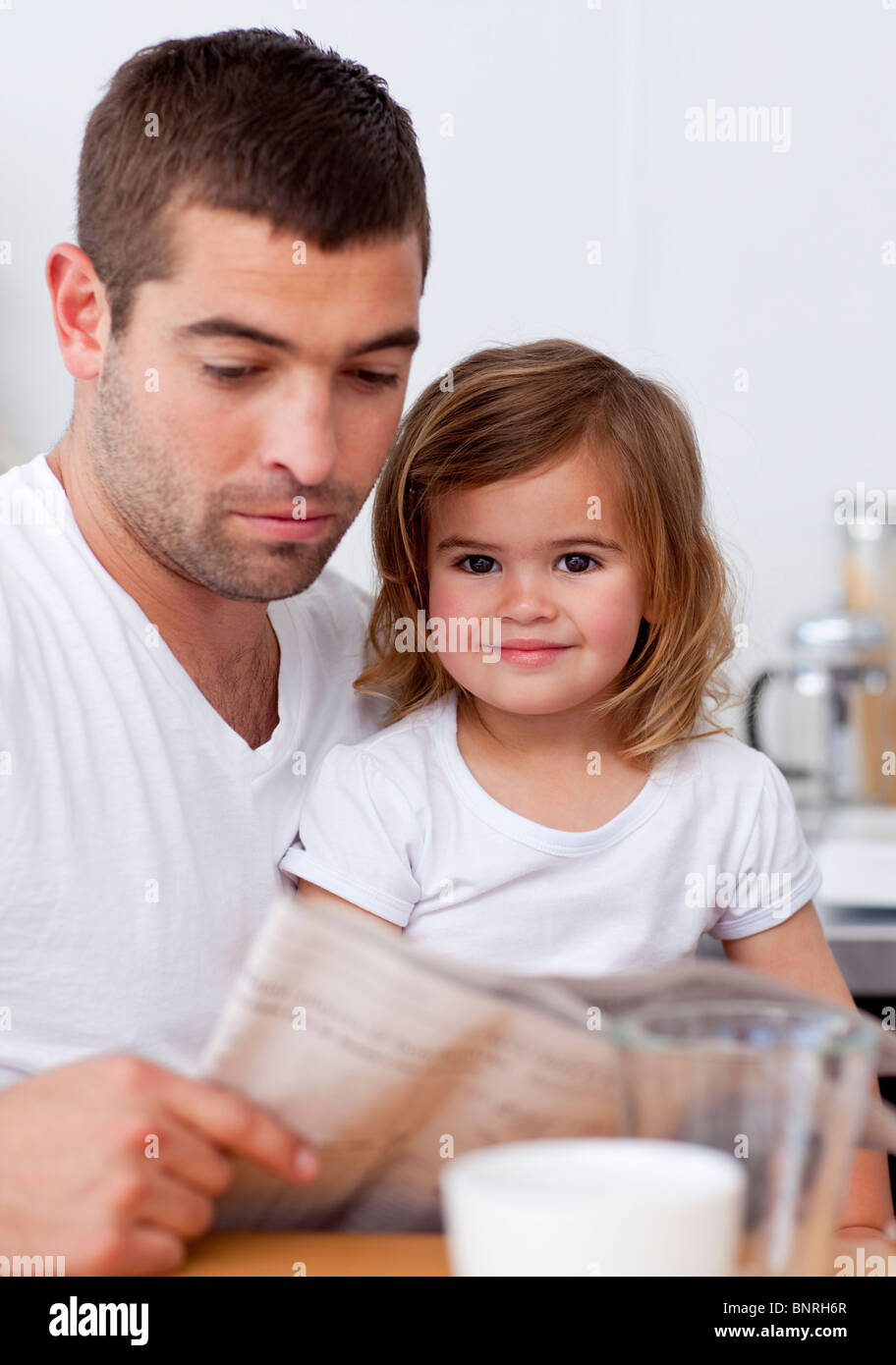Father reading a newspaper with his daughter Stock Photo - Alamy