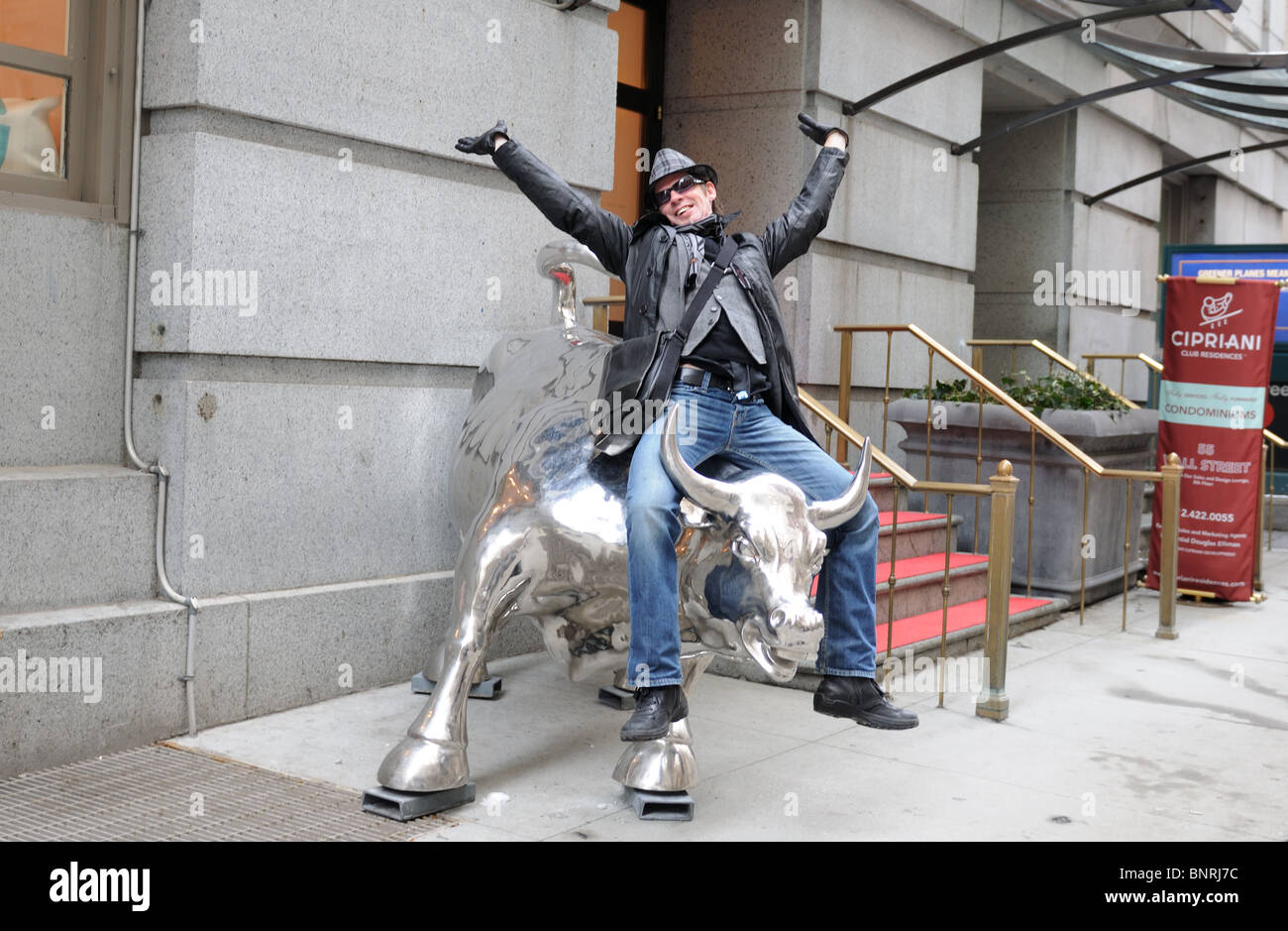 A tourist from Montreal takes a ride on a silver bull outside a Wall ...