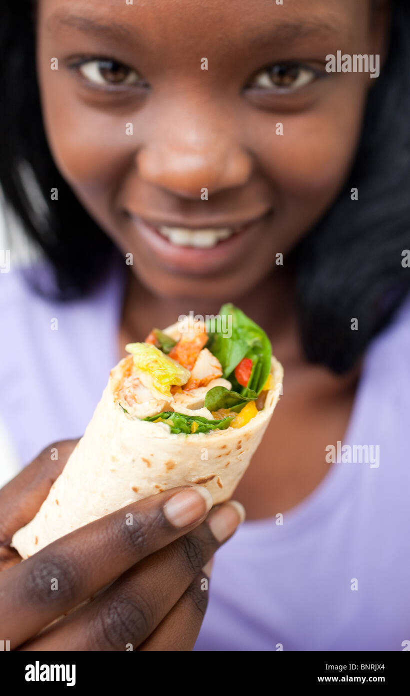 Attractive woman eating a wrap Stock Photo - Alamy