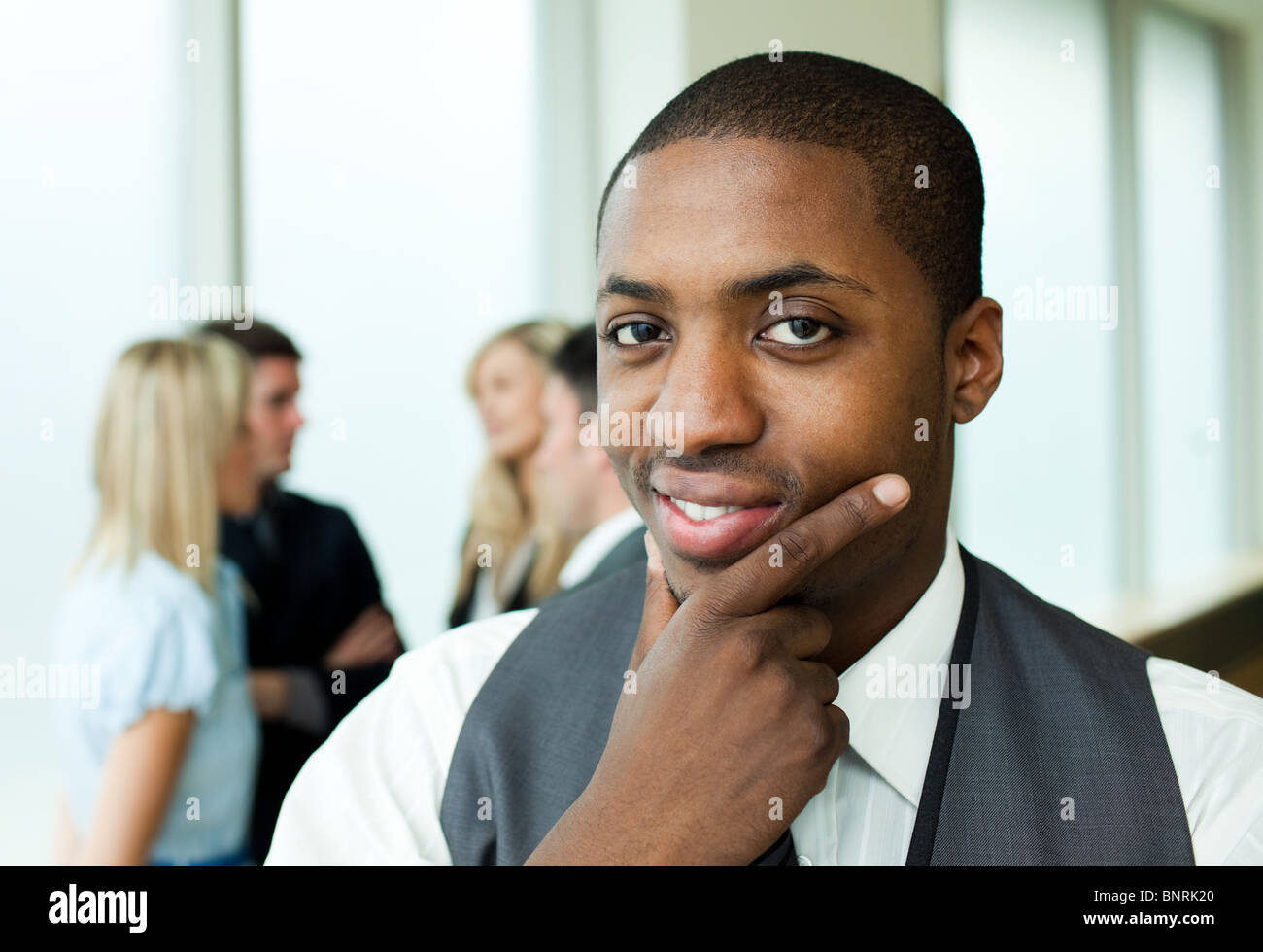 Thoughtful businessman smiling at the camera Stock Photo - Alamy