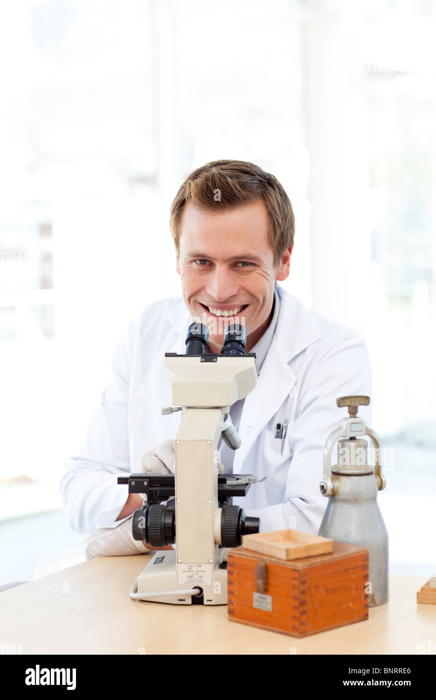 Male scientist looking through a microscope with copy-space Stock Photo ...
