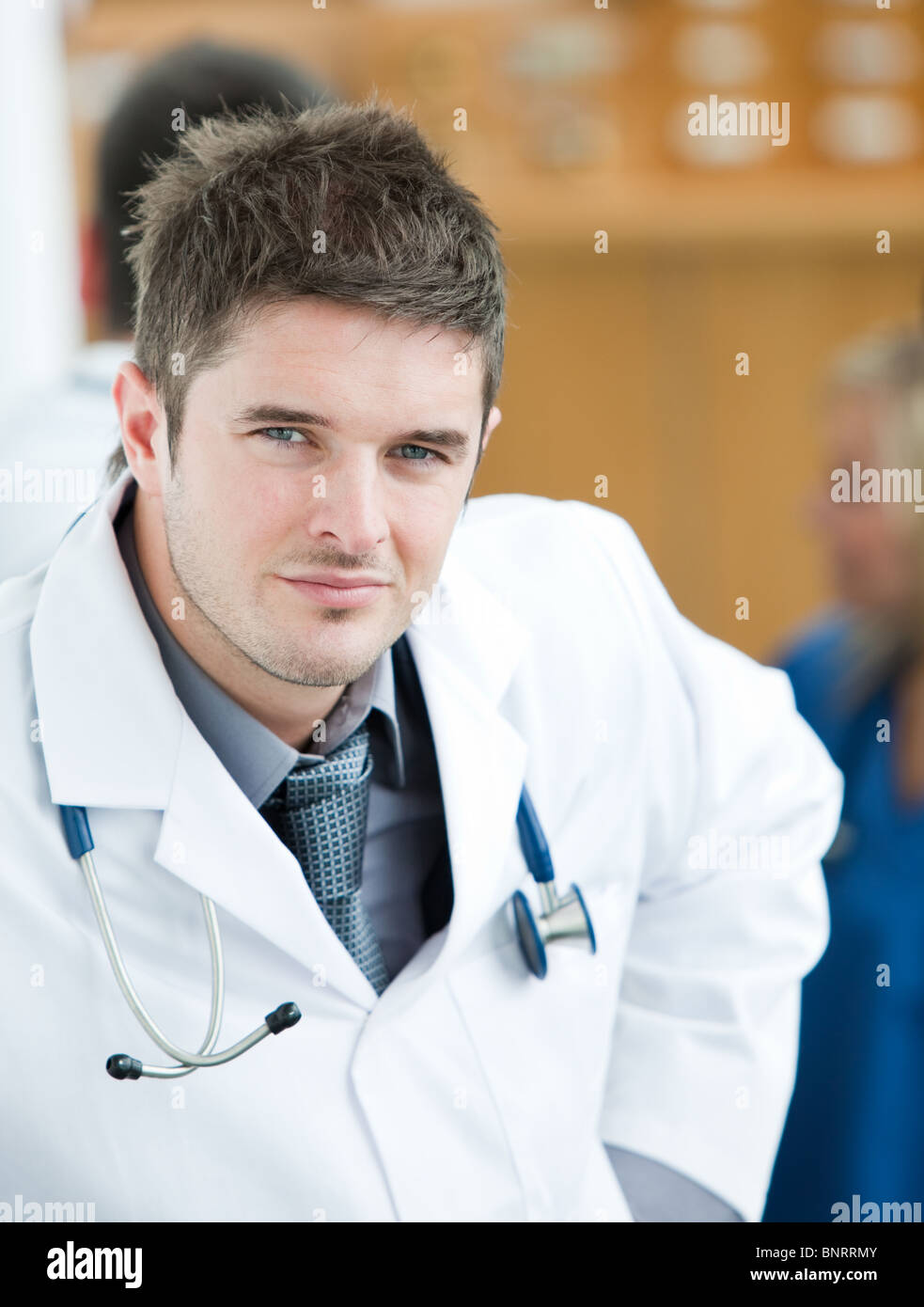 Portrait of a handsome surgeon with his team behind him Stock Photo - Alamy