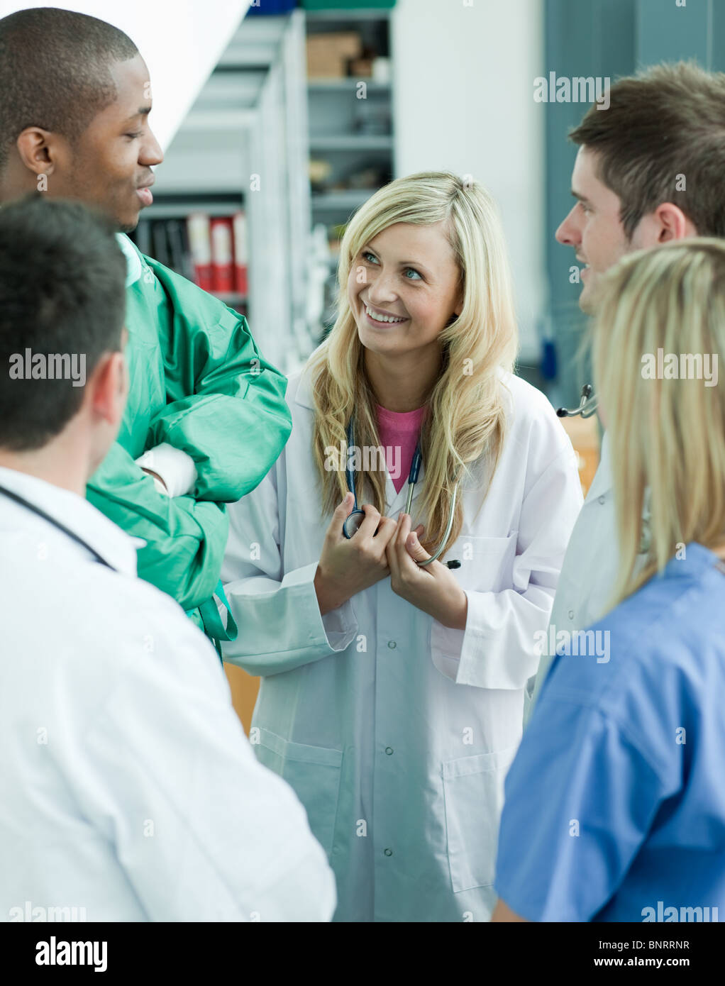 Medical team of five doctors talking Stock Photo - Alamy