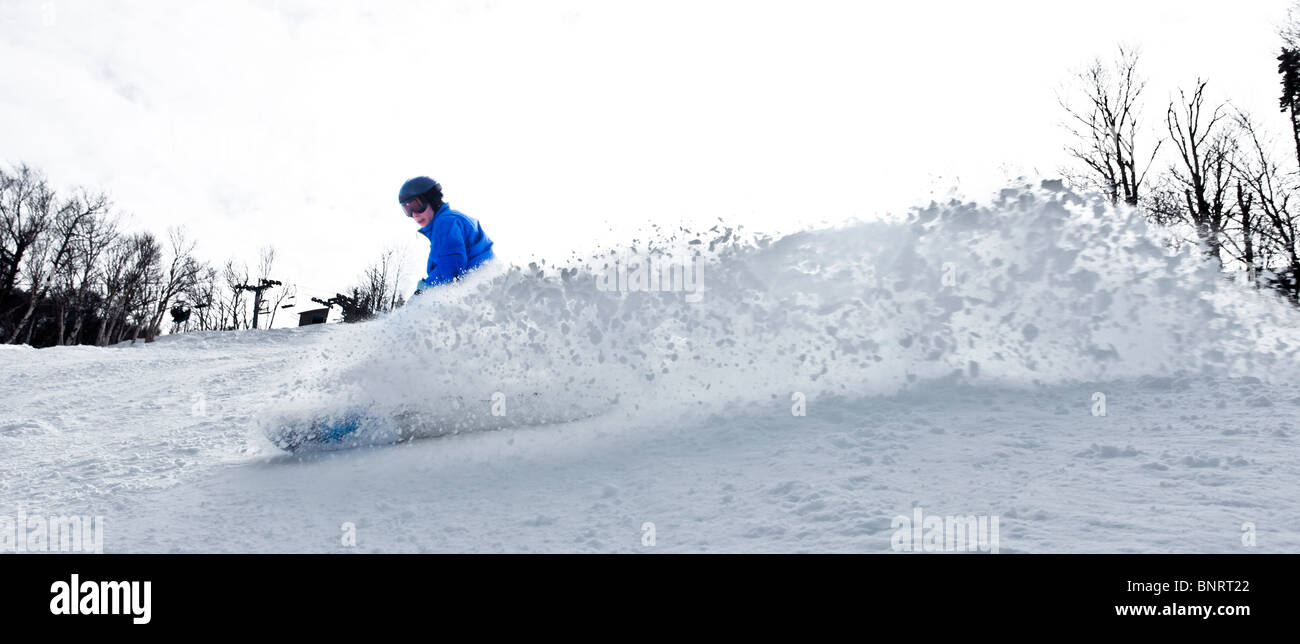 A female snowboarder kicks up snow in New Hampshire Stock Photo - Alamy