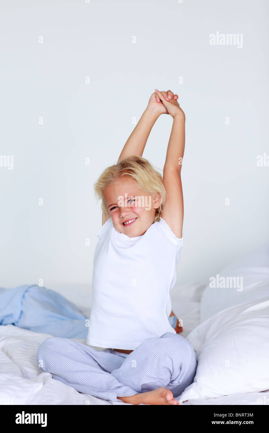Blonde girl stretching in bed Stock Photo - Alamy