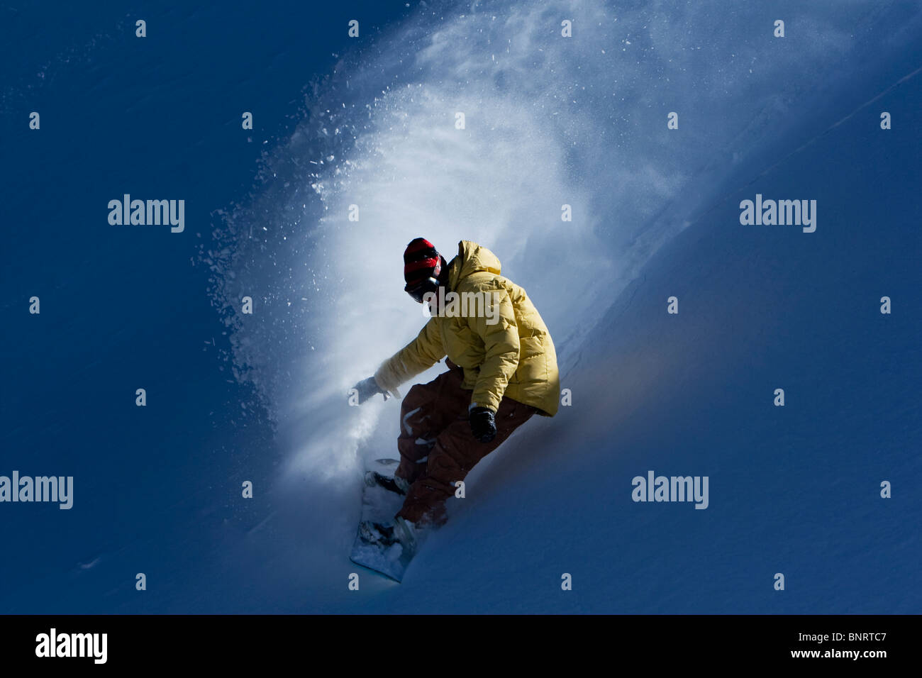 A male snowboarder catches last light on a powder day in Colorado Stock ...