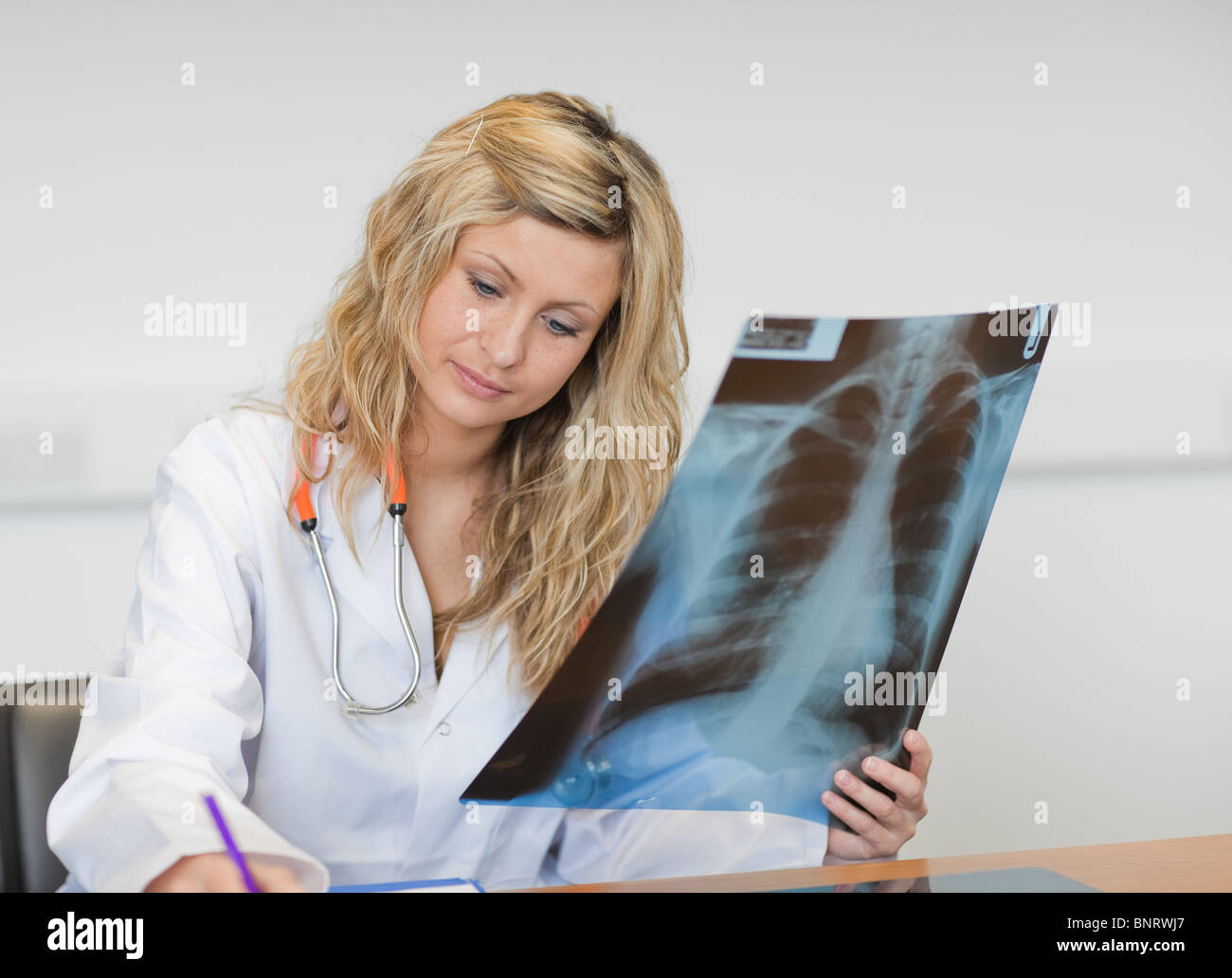 Pretty female surgeon holding a X-ray report Stock Photo - Alamy